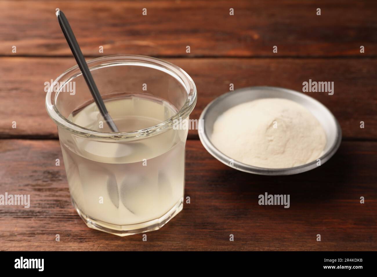 Glass of agar-agar jelly and bowl with powder on wooden table Stock ...