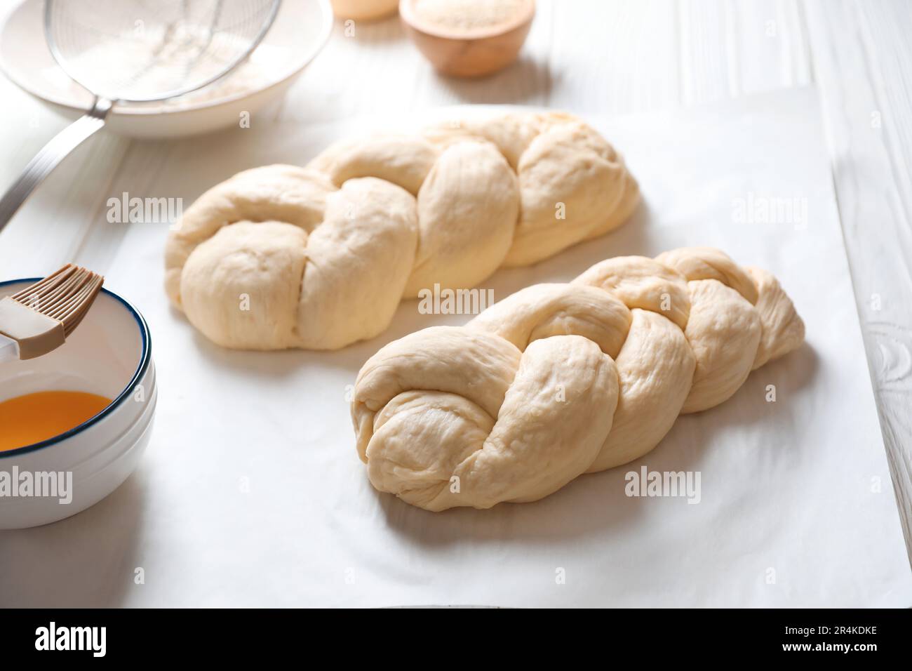 Homemade braided breads and ingredients on white wooden table, above ...