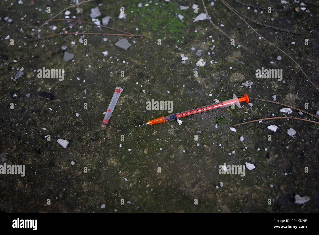 Empty disposable syringe with needle on street Stock Photo - Alamy