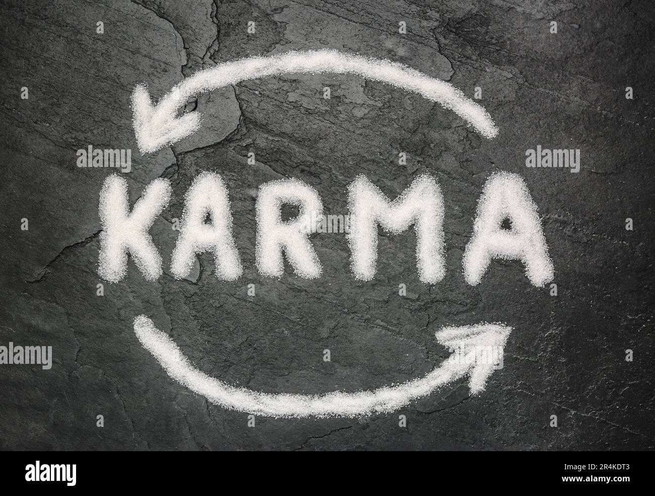 Drawn circle and word Karma made of sea salt on dark background, flat ...
