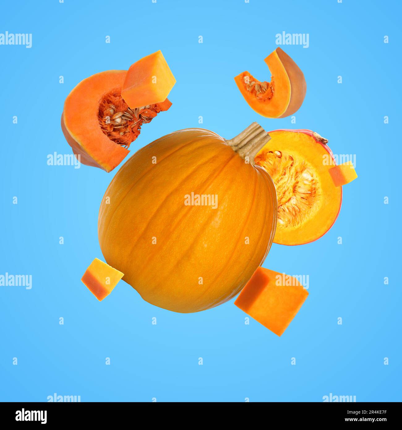 Whole and cut pumpkins falling on light blue background Stock Photo - Alamy