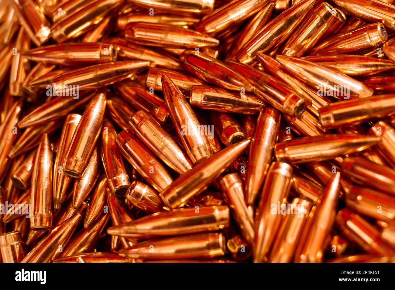 Glowing large caliber bullet heap for riffle as background Stock Photo ...