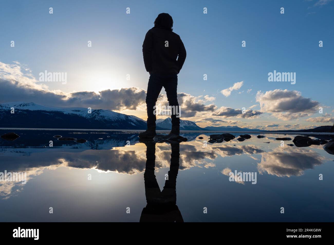 Unique view of a person with reflection in a natural lake with clouds ...