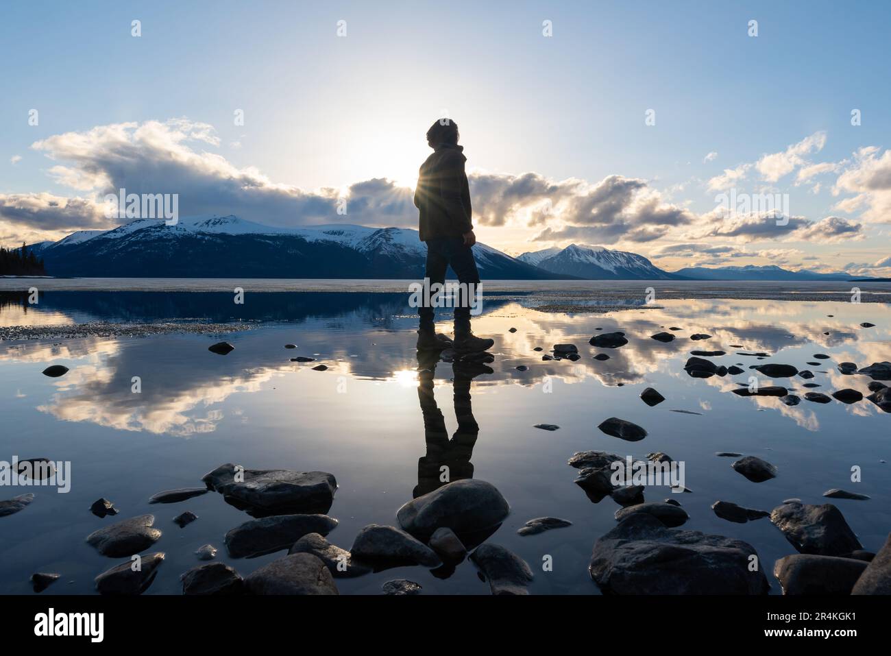 Unique view of a person with reflection in a natural lake with clouds ...