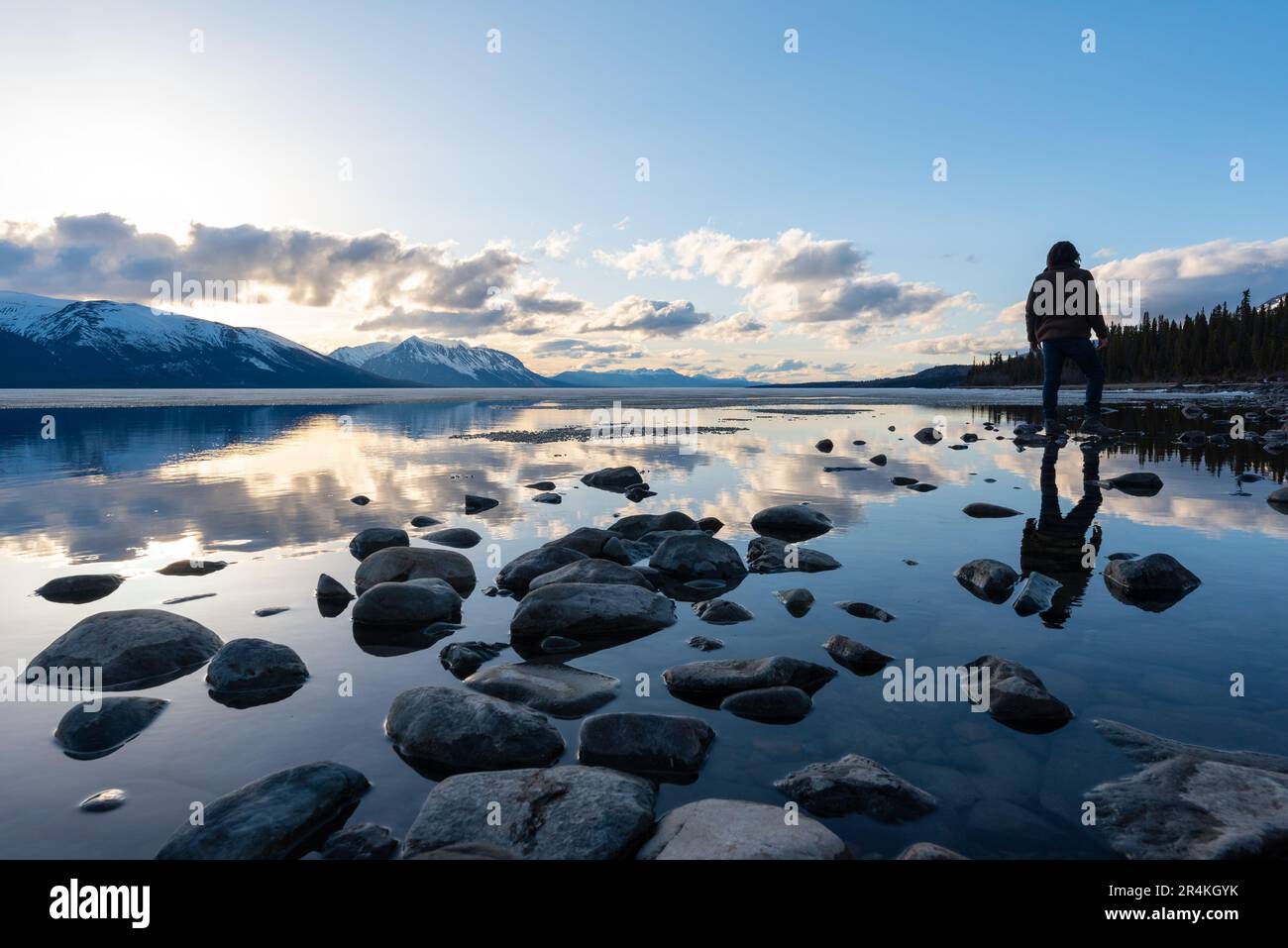 Tourist standing beside huge lake in Atlin, British Columbia during ...