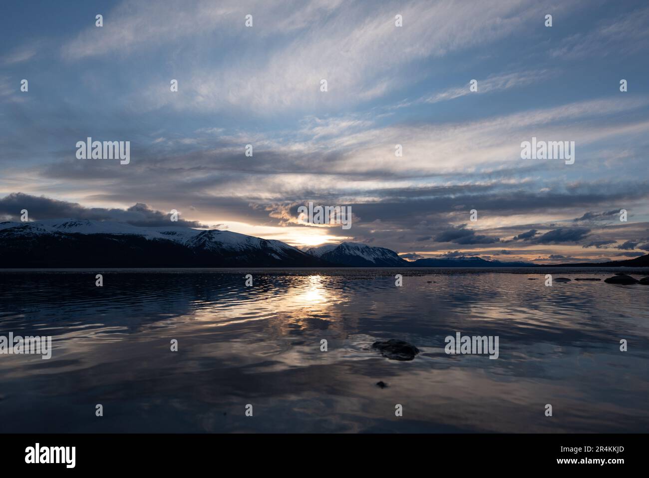 Rocky lakeshore sunset in Atlin, British Columbia during spring time ...