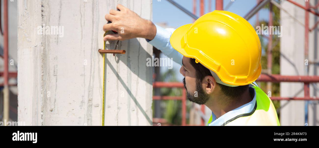 Engineer young man using tape measure for check and examining length of ...