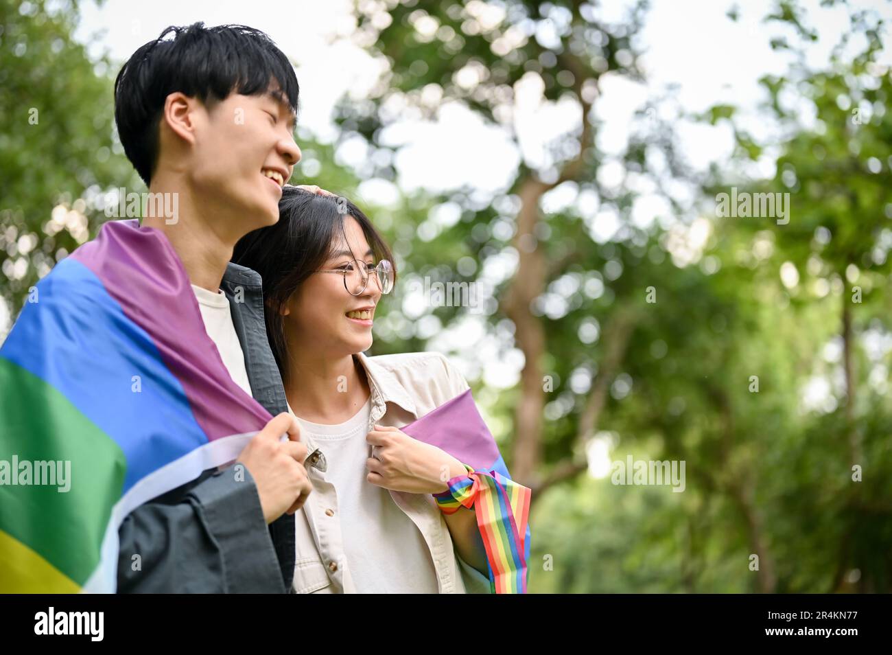 Happy young Asian couple gently loving and hugging with the LGBT ...