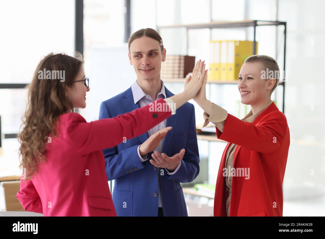 Female colleagues give high five while man boss applauds Stock Photo ...