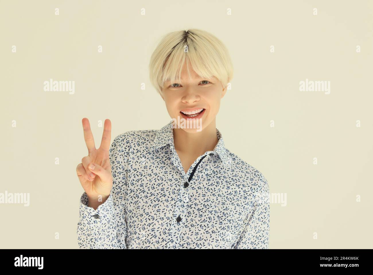 Positive blonde woman shows V sign of victory with fingers Stock Photo ...