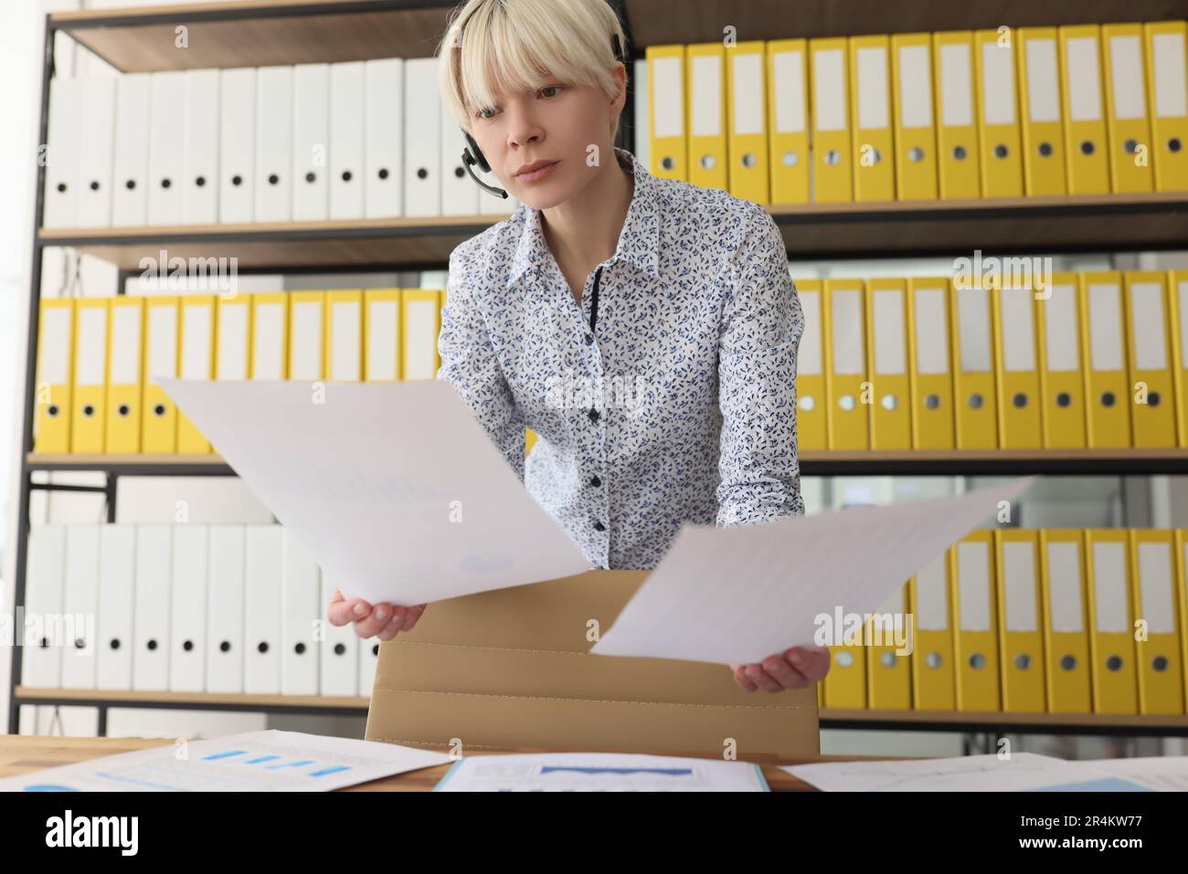 Female office worker does paperwork standing at archive rack Stock ...