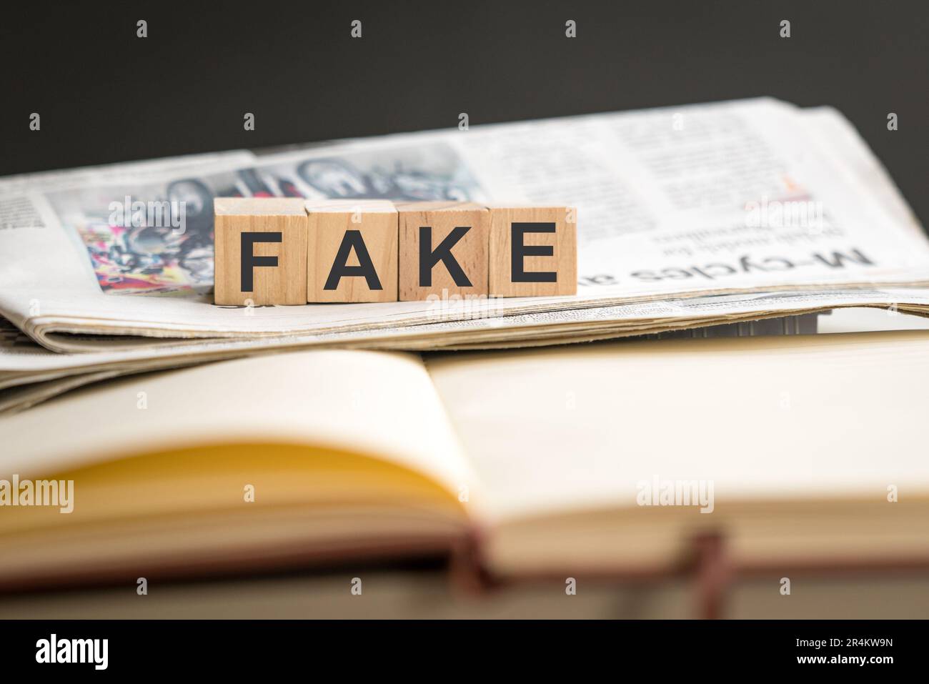 Fake, word on top of stack of newspaper Stock Photo - Alamy