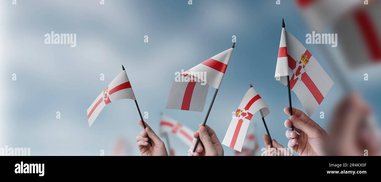 A group of people holding small flags of the Northern Ireland in their ...
