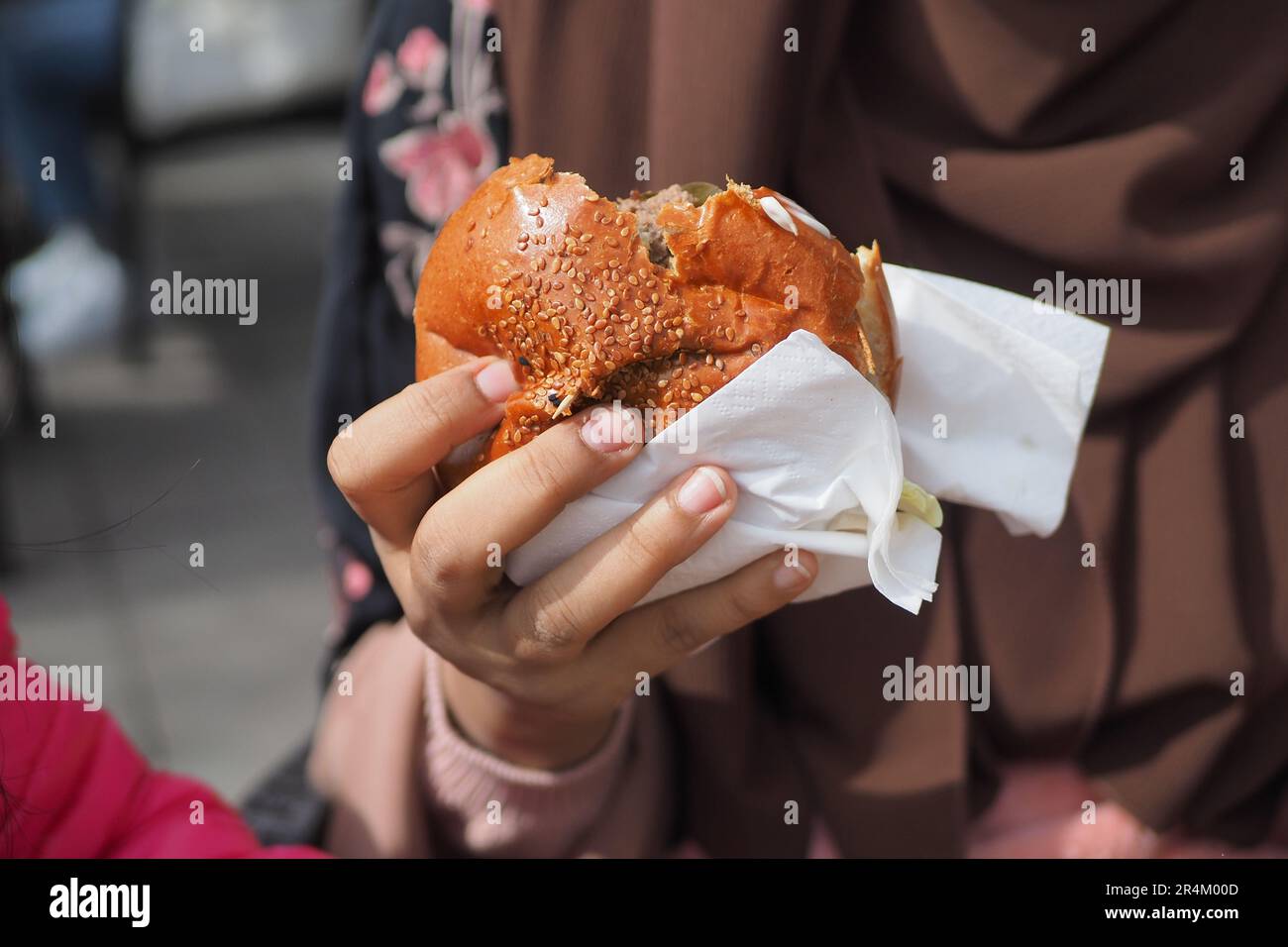 hand holding beef burger on table close up Stock Photo - Alamy
