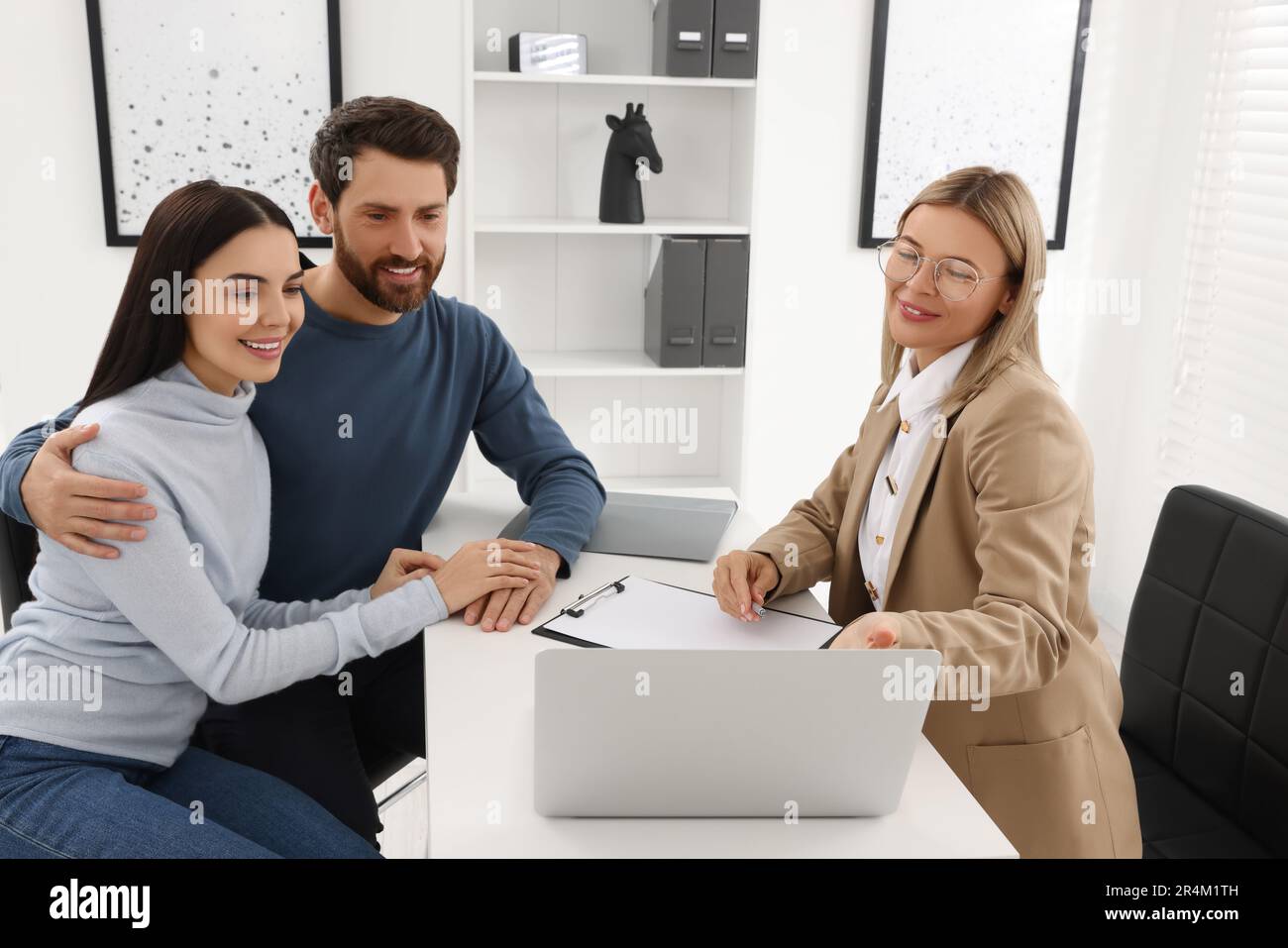 Real estate agent consulting couple in office Stock Photo - Alamy