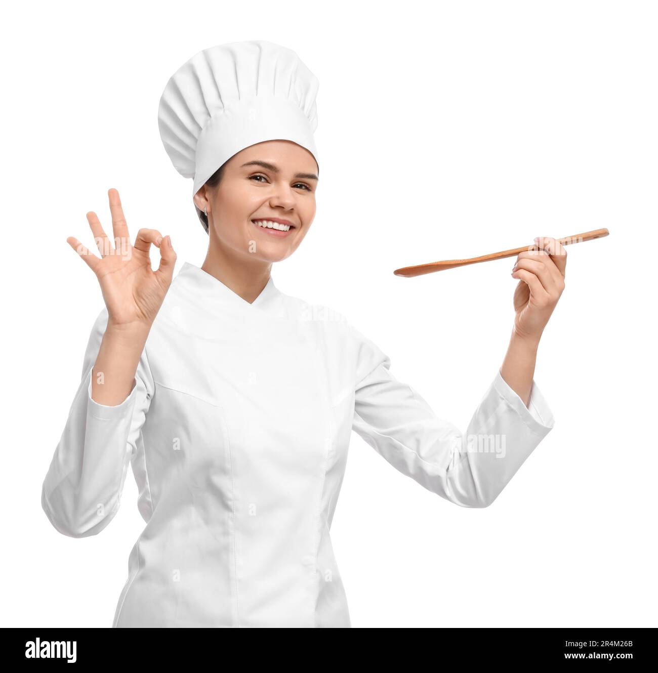 Happy female chef with wooden spoon showing ok gesture on white ...
