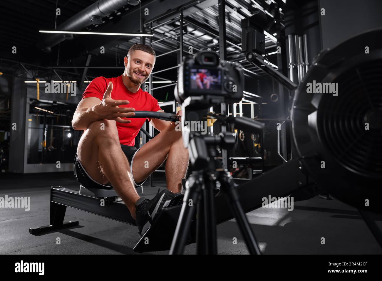 Man recording workout on camera at gym. Online fitness trainer Stock ...