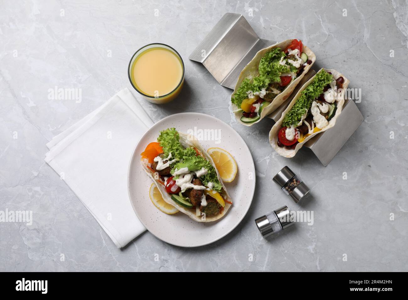 Delicious fresh vegan tacos served on light grey marble table, flat lay ...