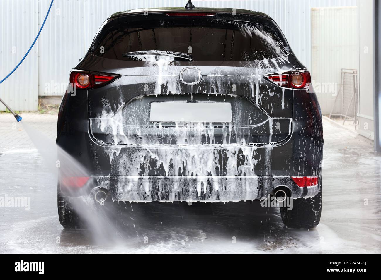 Washing auto with high pressure water jet at outdoor car wash Stock ...