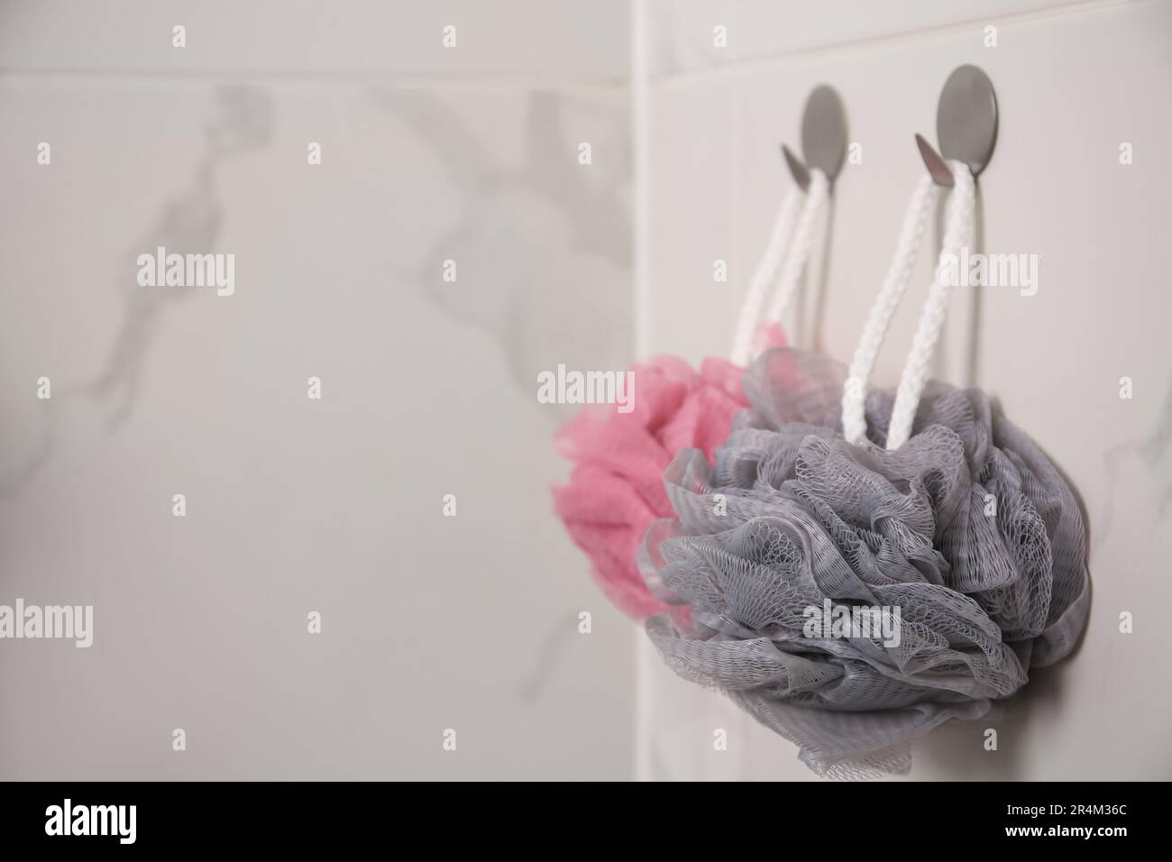 Shower puffs hanging near faucet in bathroom, space for text Stock ...