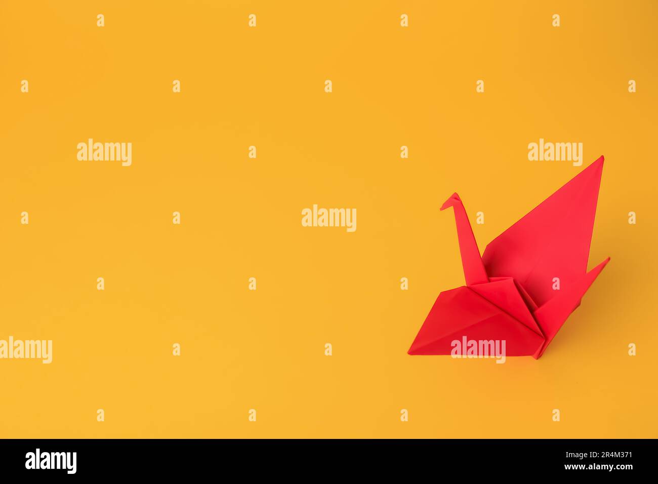 Origami art. Beautiful red paper crane on orange background, space for ...