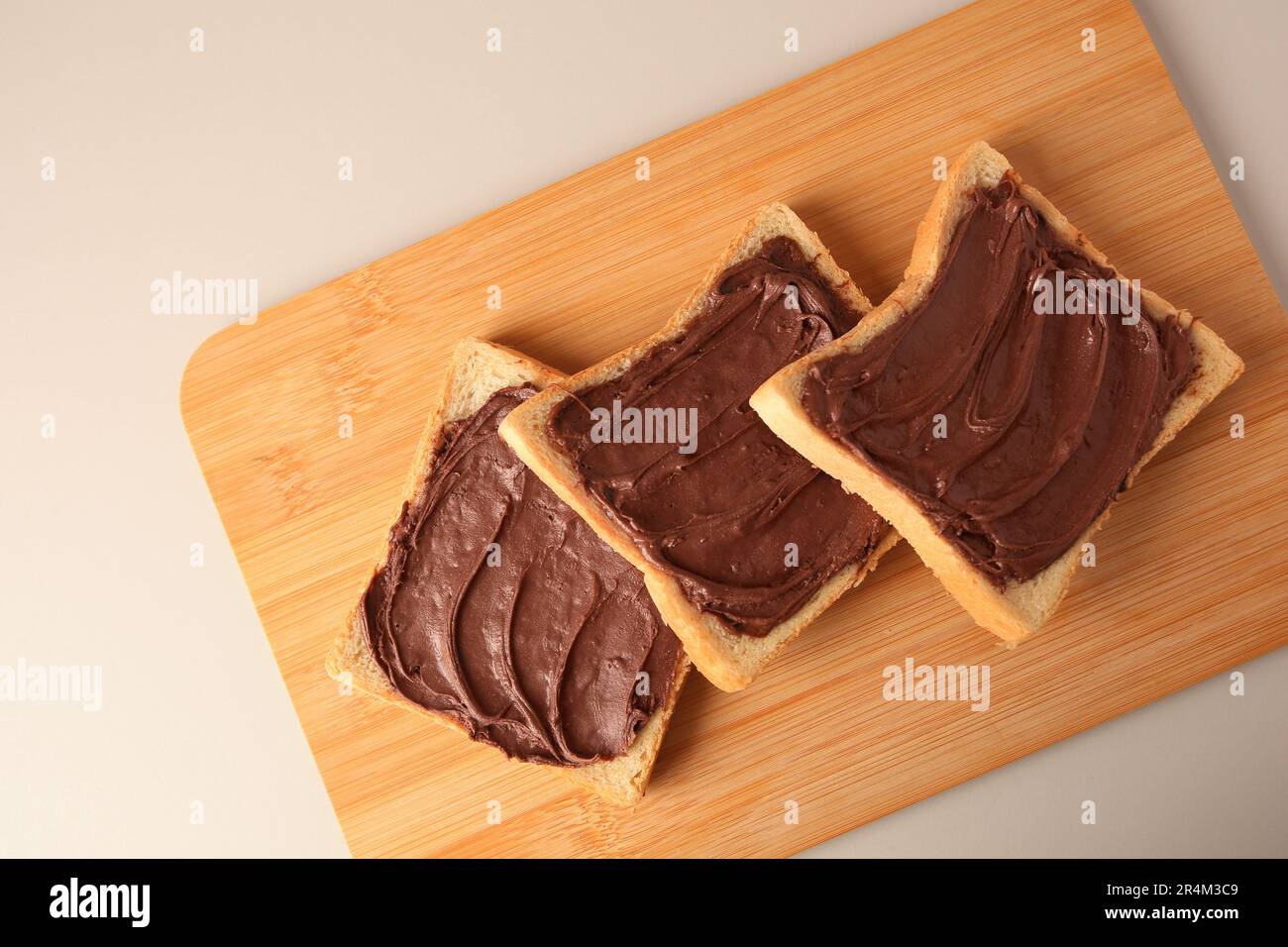 Tasty toasts with chocolate paste on beige background, top view Stock ...