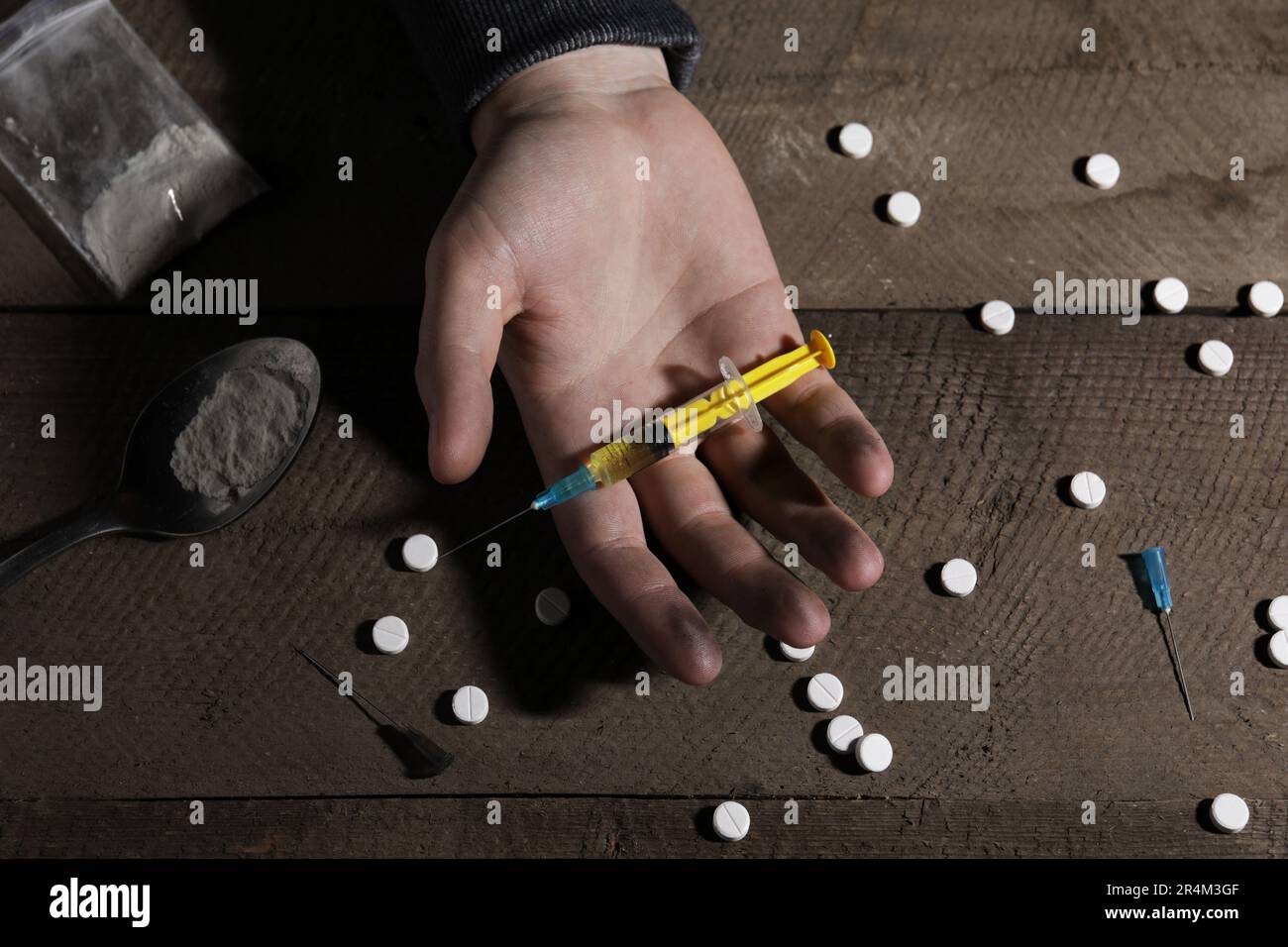 Addicted man with syringe near drugs at wooden table, top view Stock ...