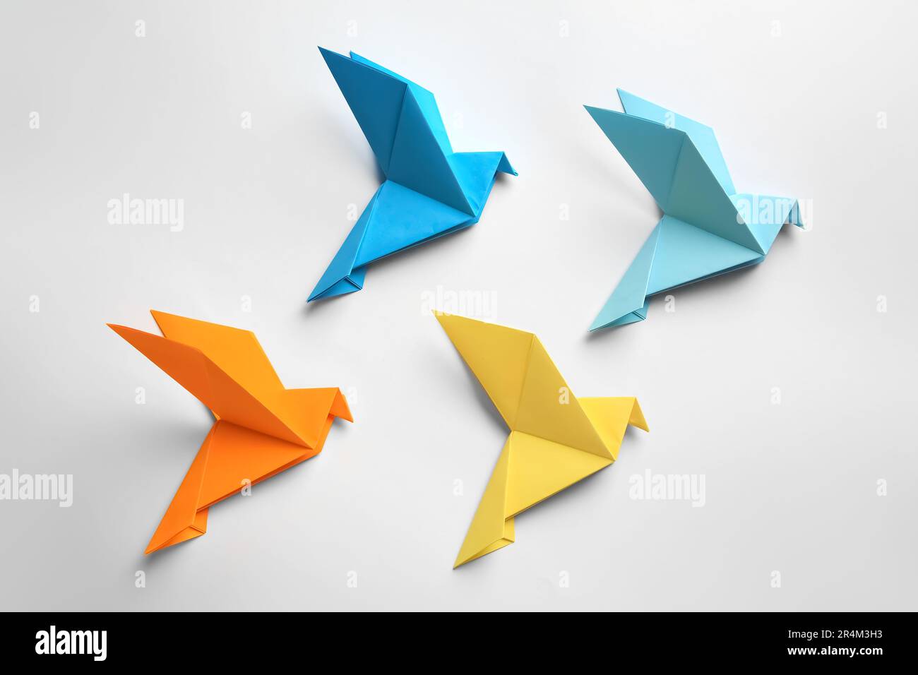Beautiful colorful origami birds on white background, flat lay Stock ...