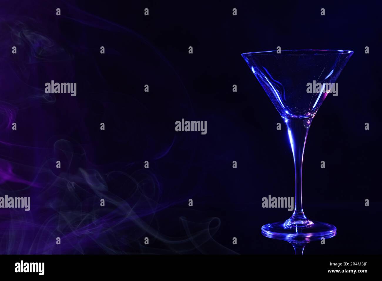 Empty clean martini glass on mirror table in neon lights, space for ...