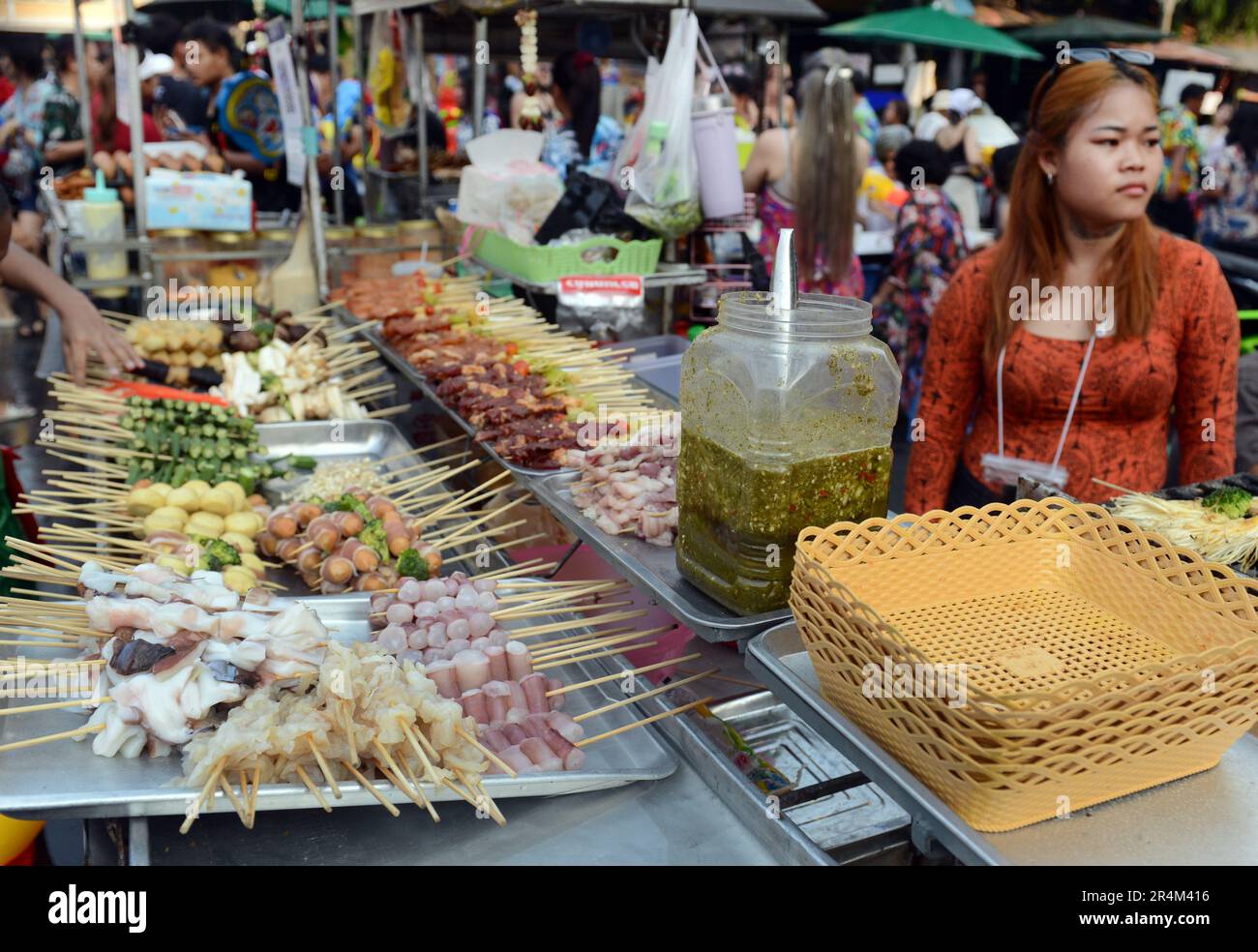 A street food vendor selling grilled meat, seafood and vegetables ...