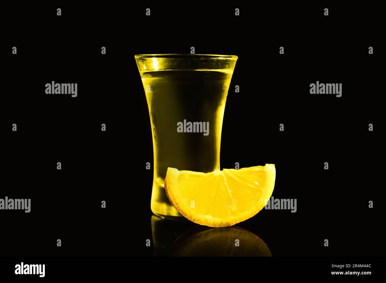 Shot glass of vodka with lemon slice on dark background Stock Photo - Alamy