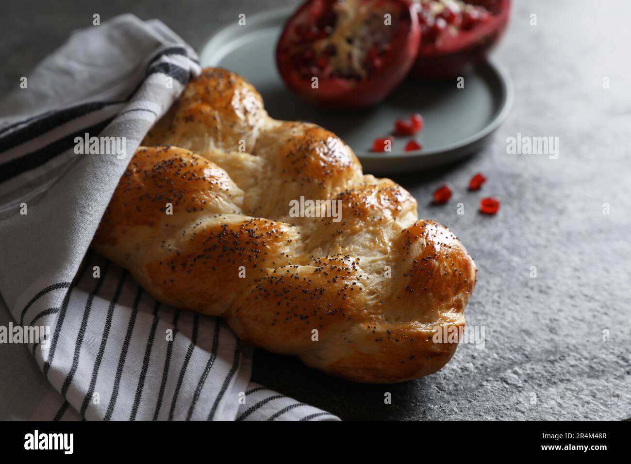 Homemade braided bread and pomegranate on grey table. Cooking ...