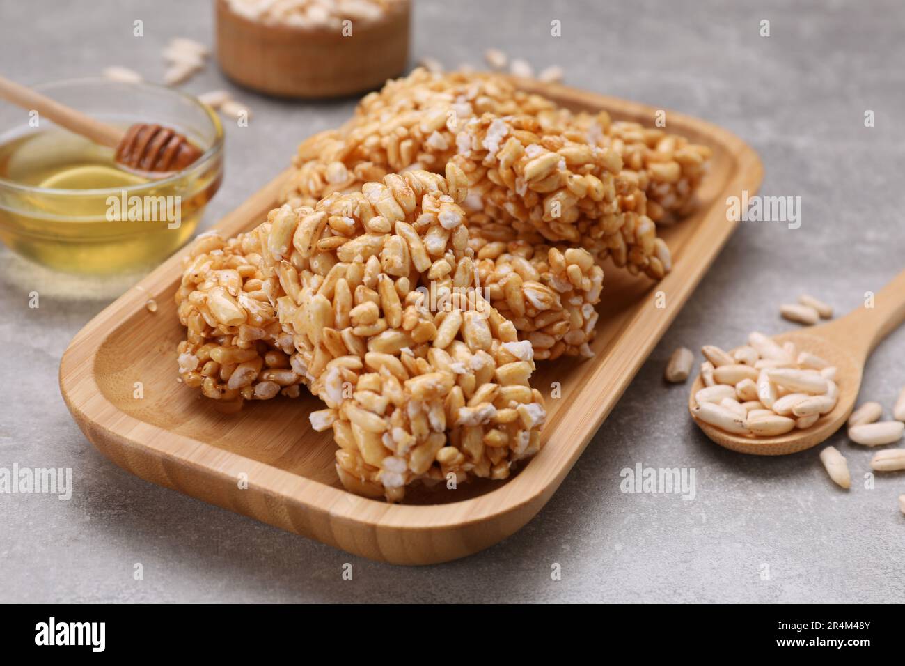 Plate with puffed rice pieces (kozinaki) on grey table Stock Photo - Alamy