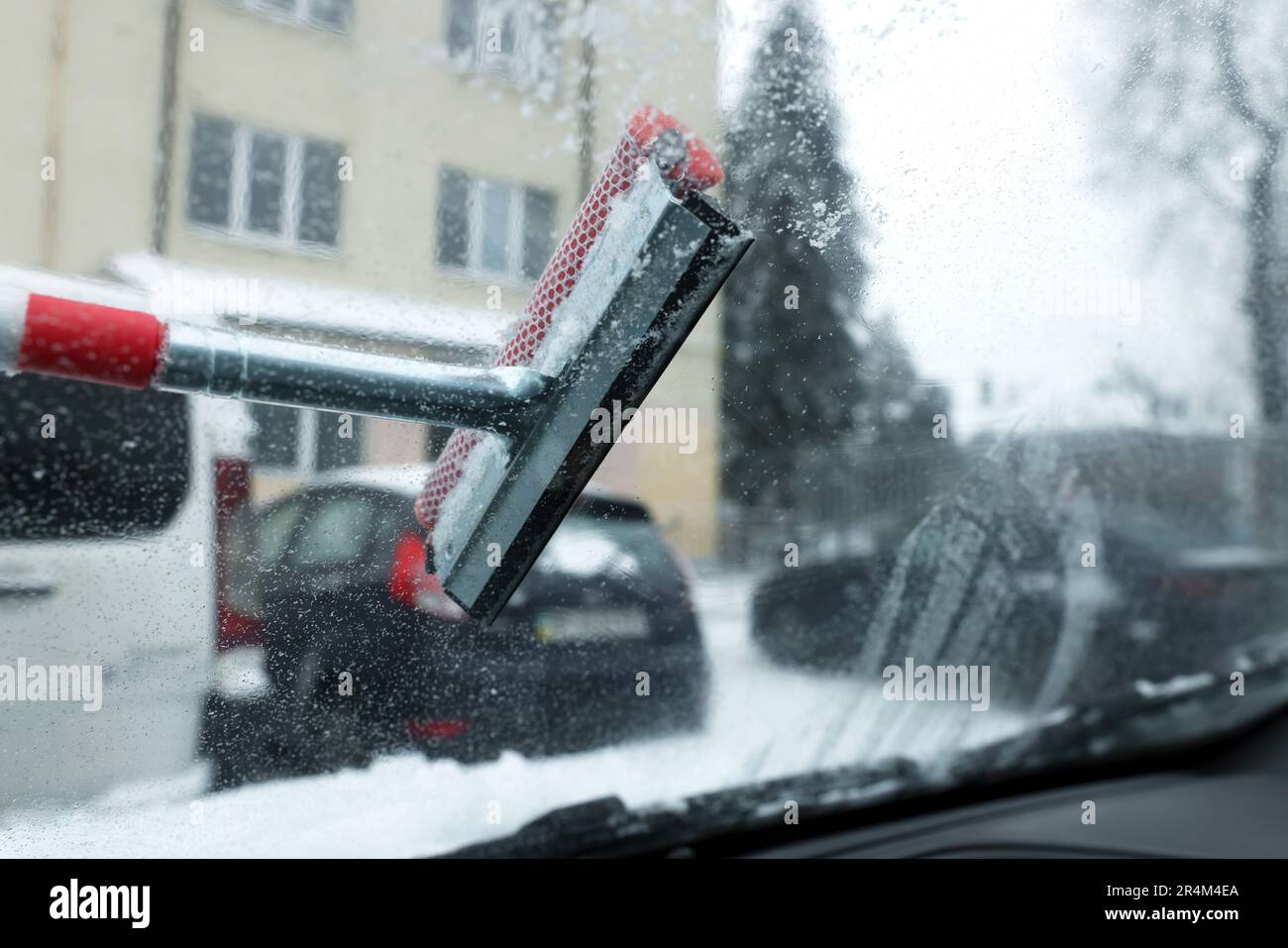Cleaning windshield from snow with squeegee, view from inside Stock ...