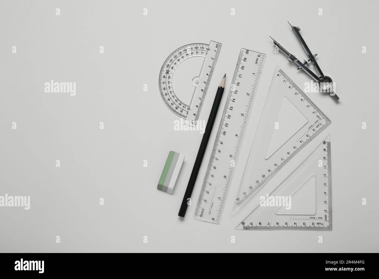 Different rulers and compass on yellow background, flat lay. Space for ...