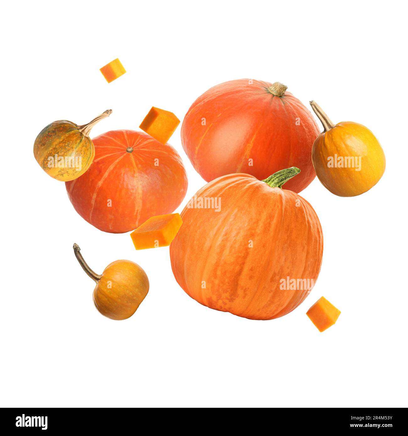 Whole and cut pumpkins falling on white background Stock Photo - Alamy