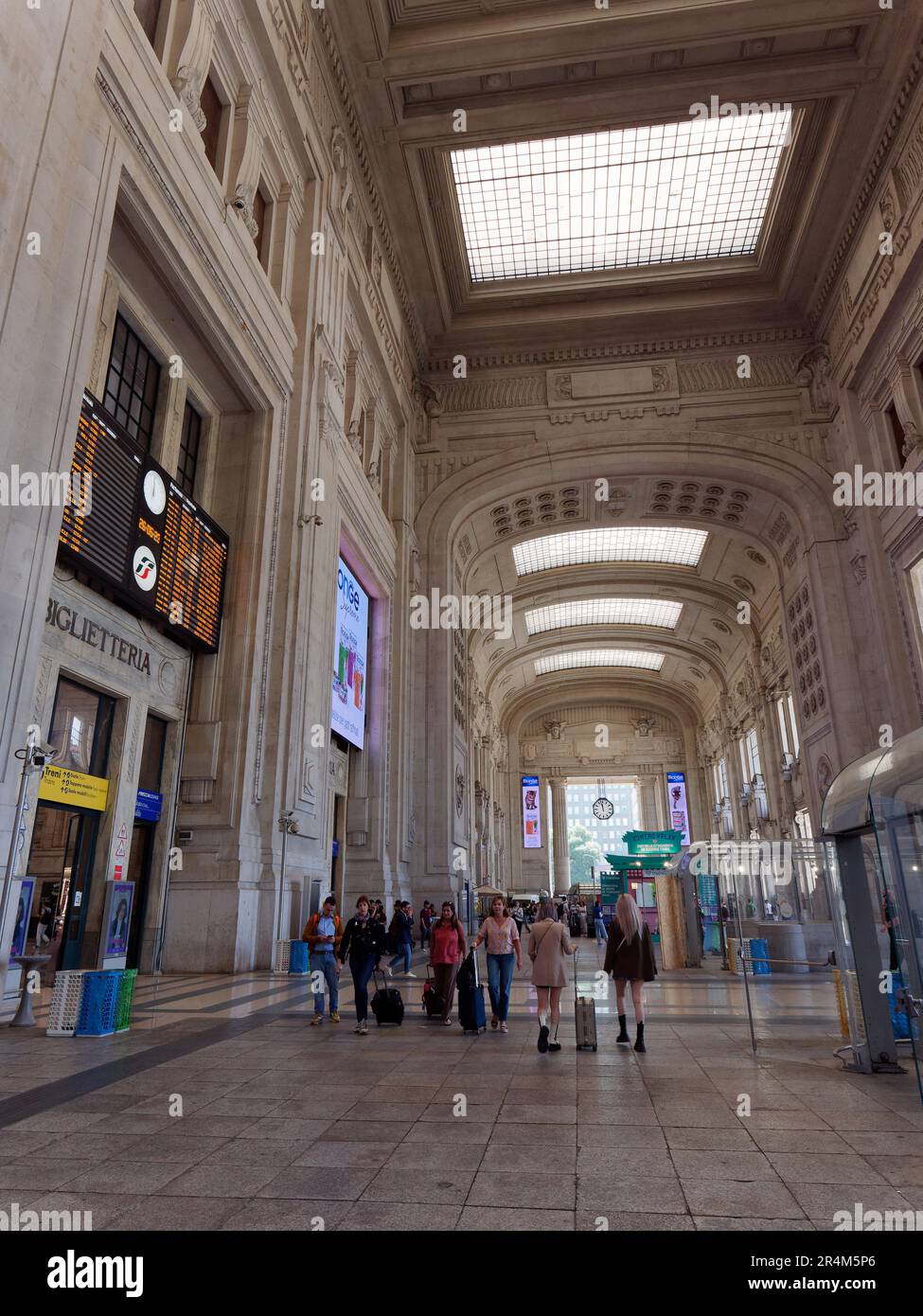 Interior of Milan Centrale Railway Station. Travellers wheel their ...