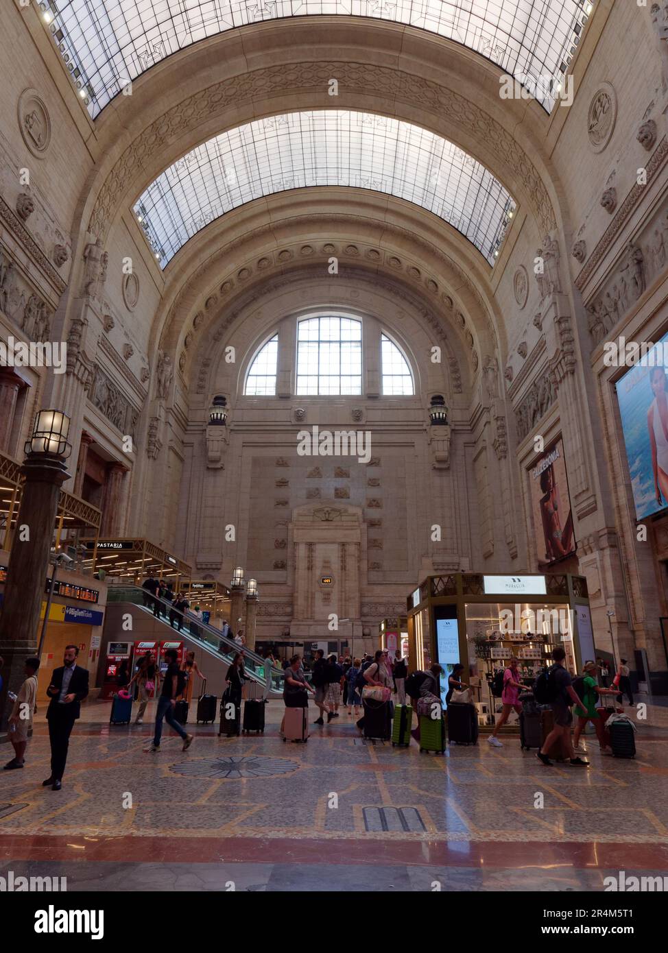 Interior of Milan Centrale Railway Station. Travellers wheel their ...