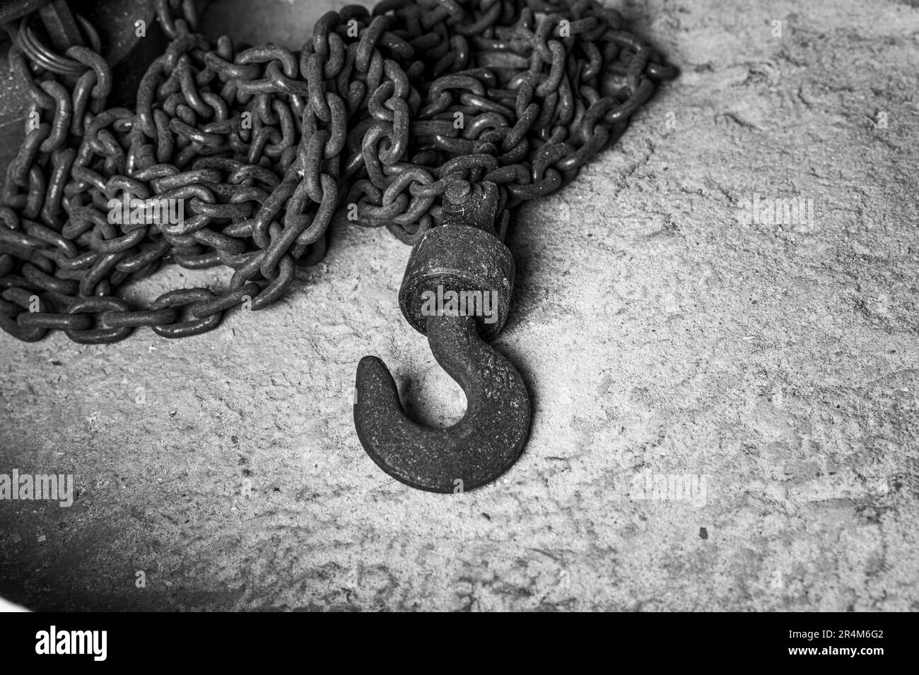 an old iron chain hoist with chain. a large hook for lifting loads ...