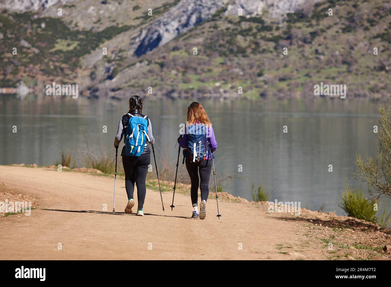 Two female backpacker hikers on a pathway. Outdoor healthy lifestyle ...