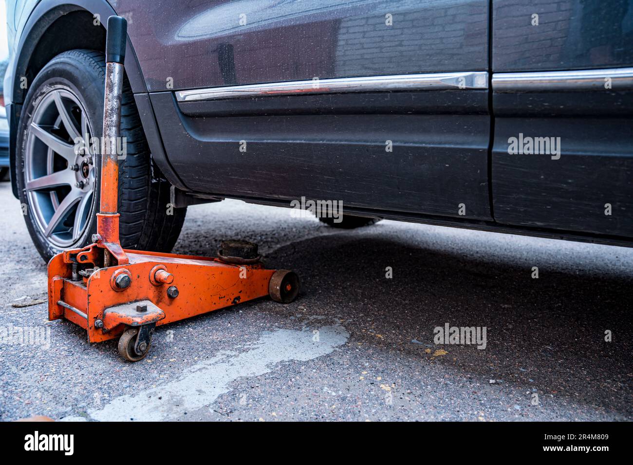 Car mechanic using jack change hi-res stock photography and images - Alamy