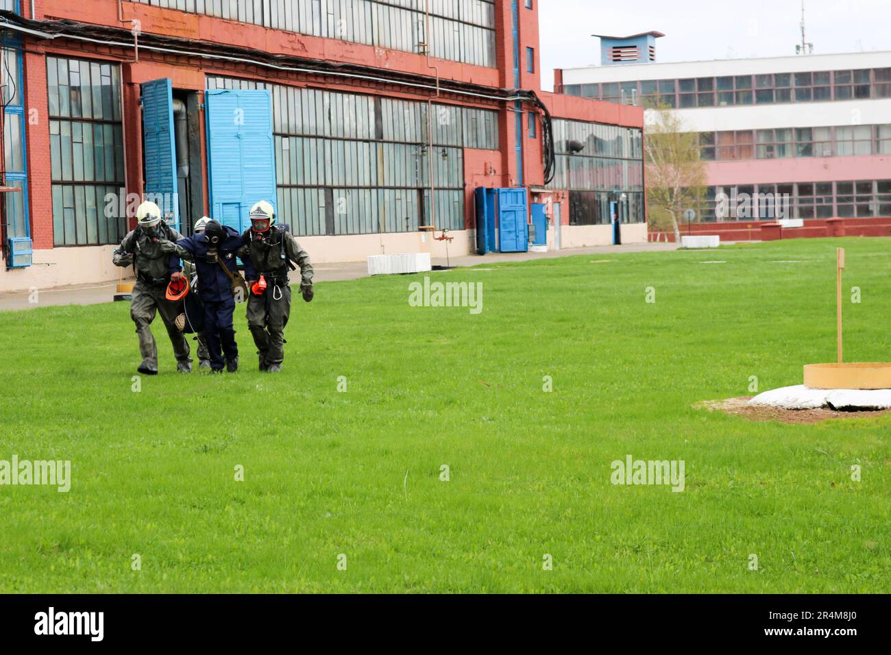 Three firefighter rescuers in protective fireproof suits and helmets ...