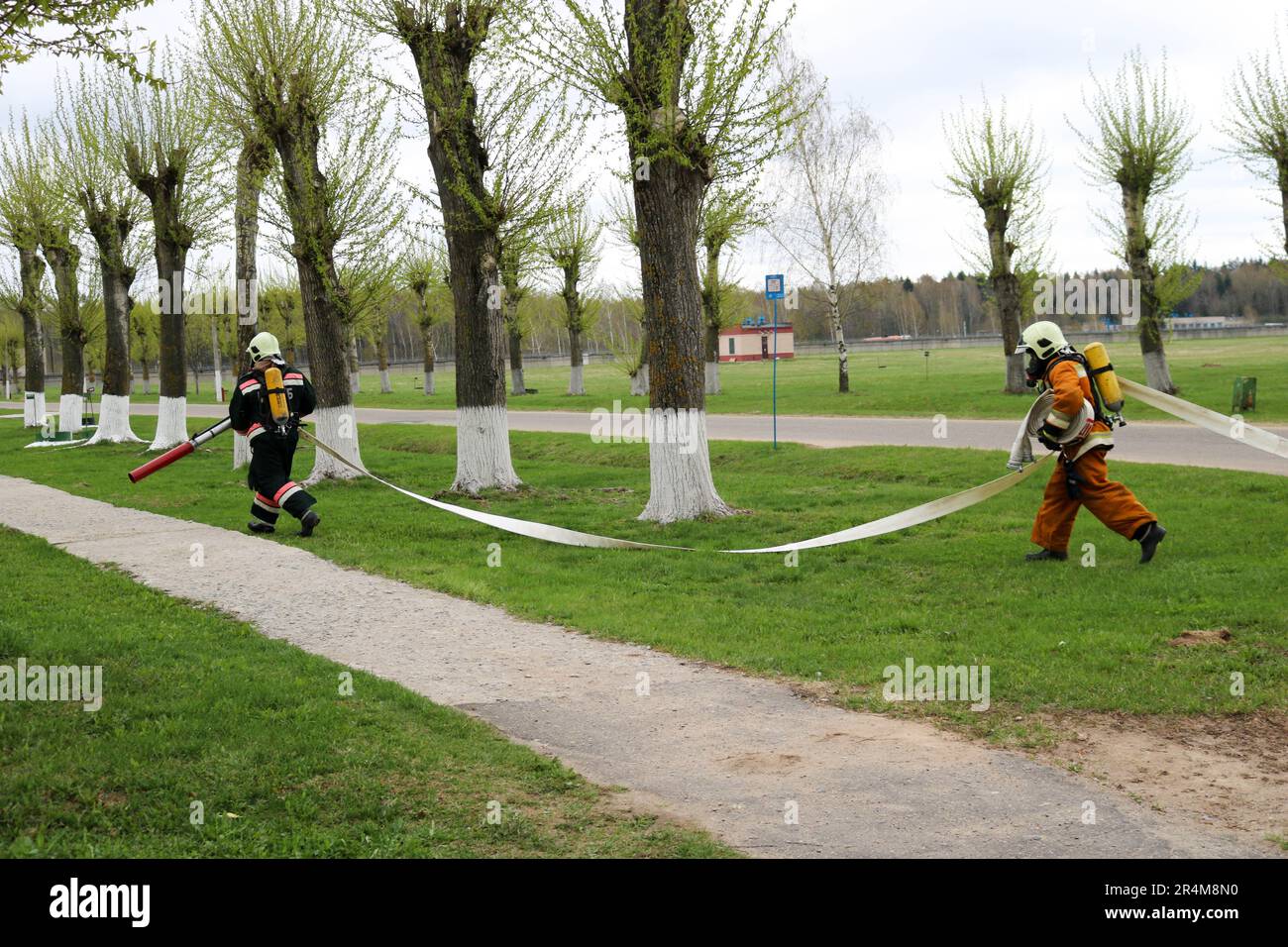 Professional firefighters, rescuers in protective fireproof suits ...