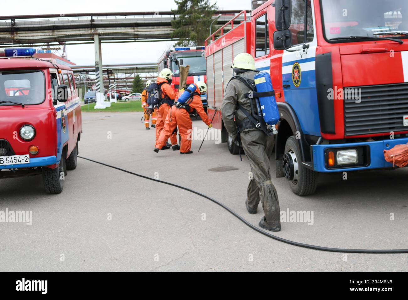 A large red fire rescue vehicle, a truck to extinguish a fire and male ...