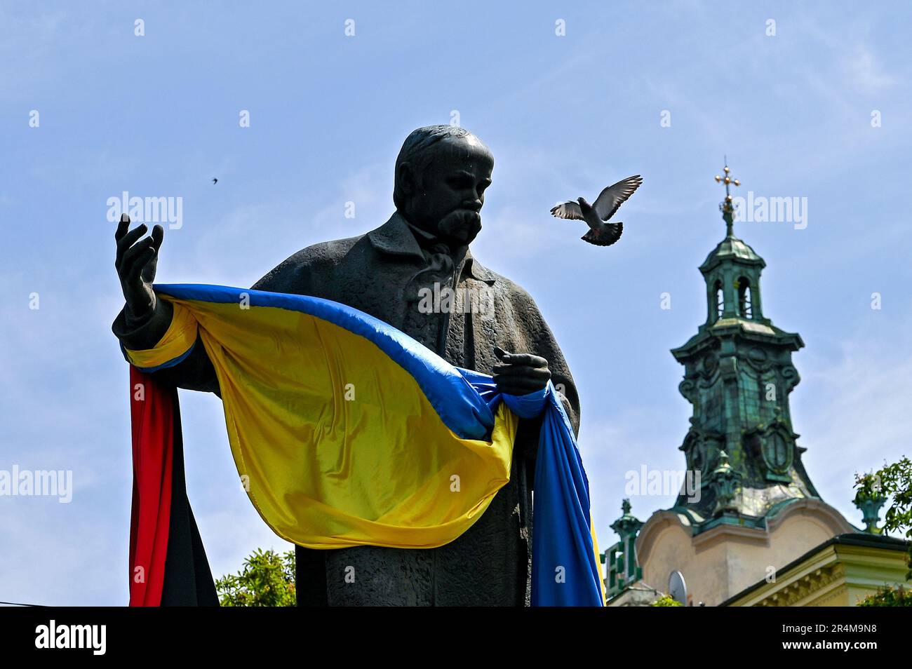 LVIV, UKRAINE - MAY 28, 2023 - A pigeon flies past the monument to ...