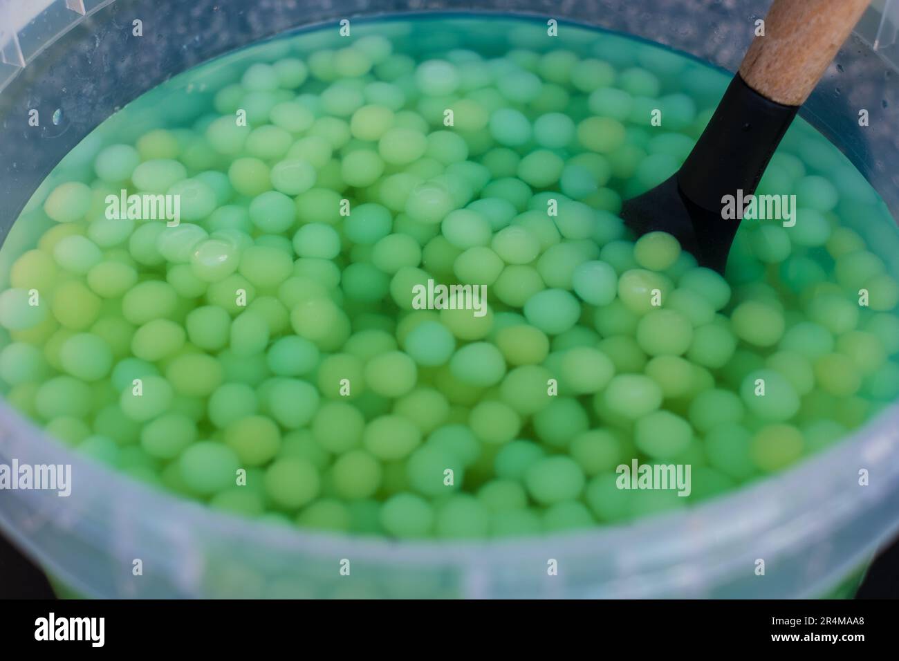 Large bucket full of green boba balls in liquid Stock Photo - Alamy