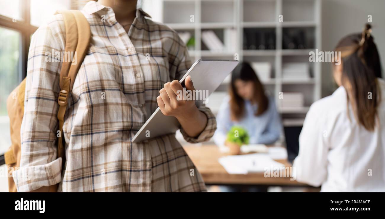 Close up of Young student with backpack carrying digital tablet in ...