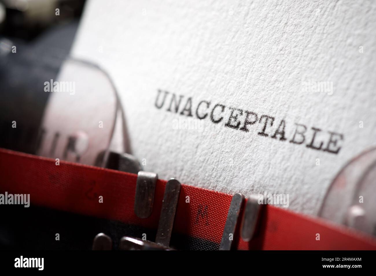 Unacceptable word written with a typewriter Stock Photo - Alamy