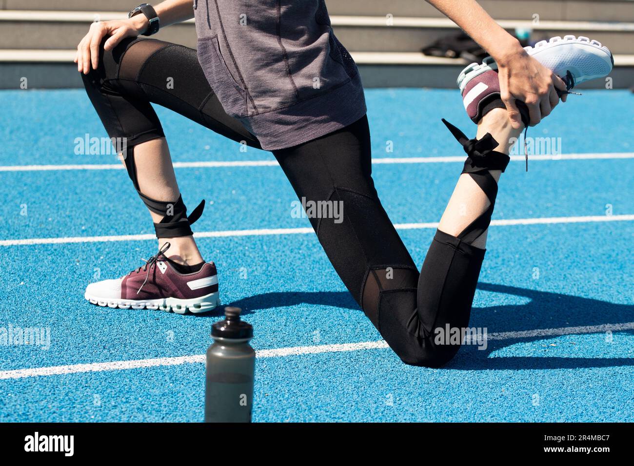 Female track and field athlete doing stretching exercises (symbol image ...