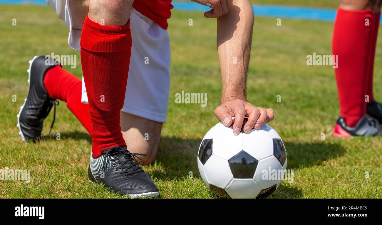 Close-up of a football and a player wearing red socks (symbol image ...